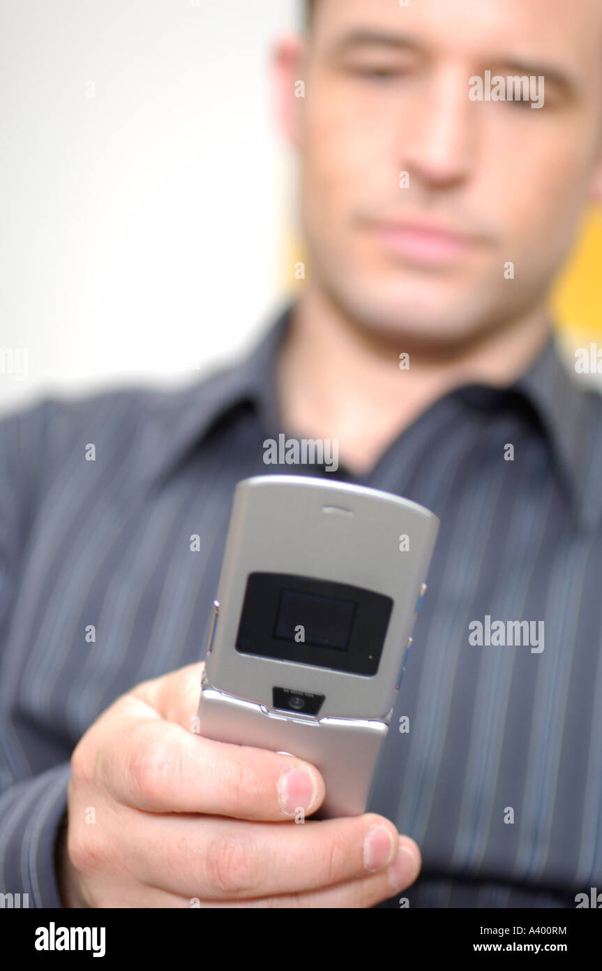 young man checking his mobile phone for text messages Stock Photo - Alamy