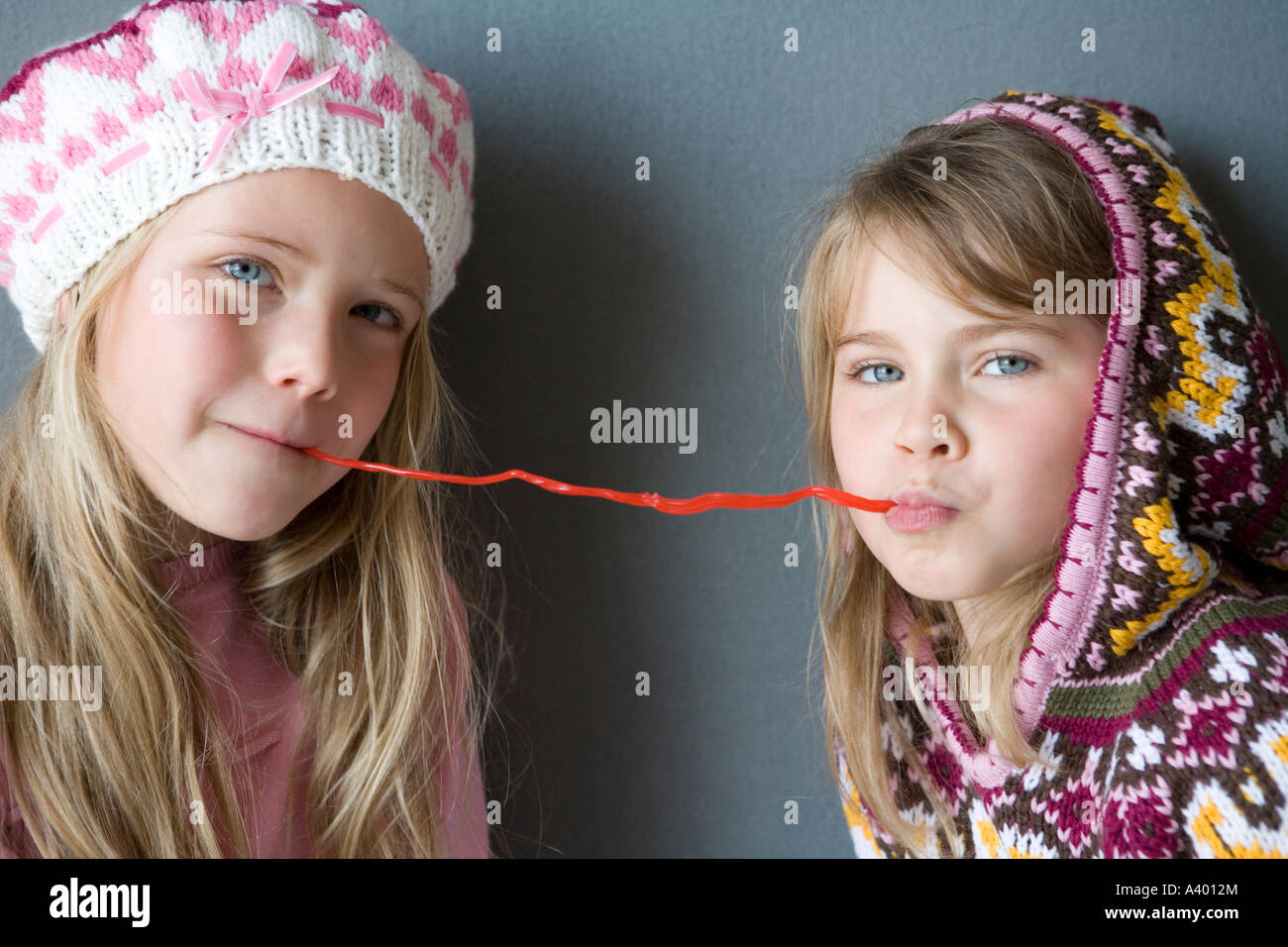 portrait of two siblings eating sweets together Stock Photo - Alamy