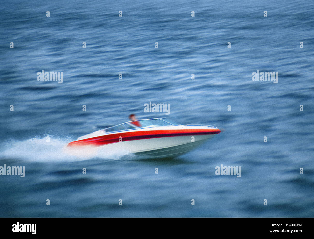 Blurred white speedboat with red stripe, racing across the water Stock ...