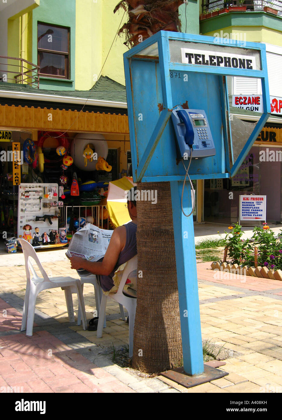 Man reading newspaper by telephone booth Alanya Turkey Stock Photo - Alamy