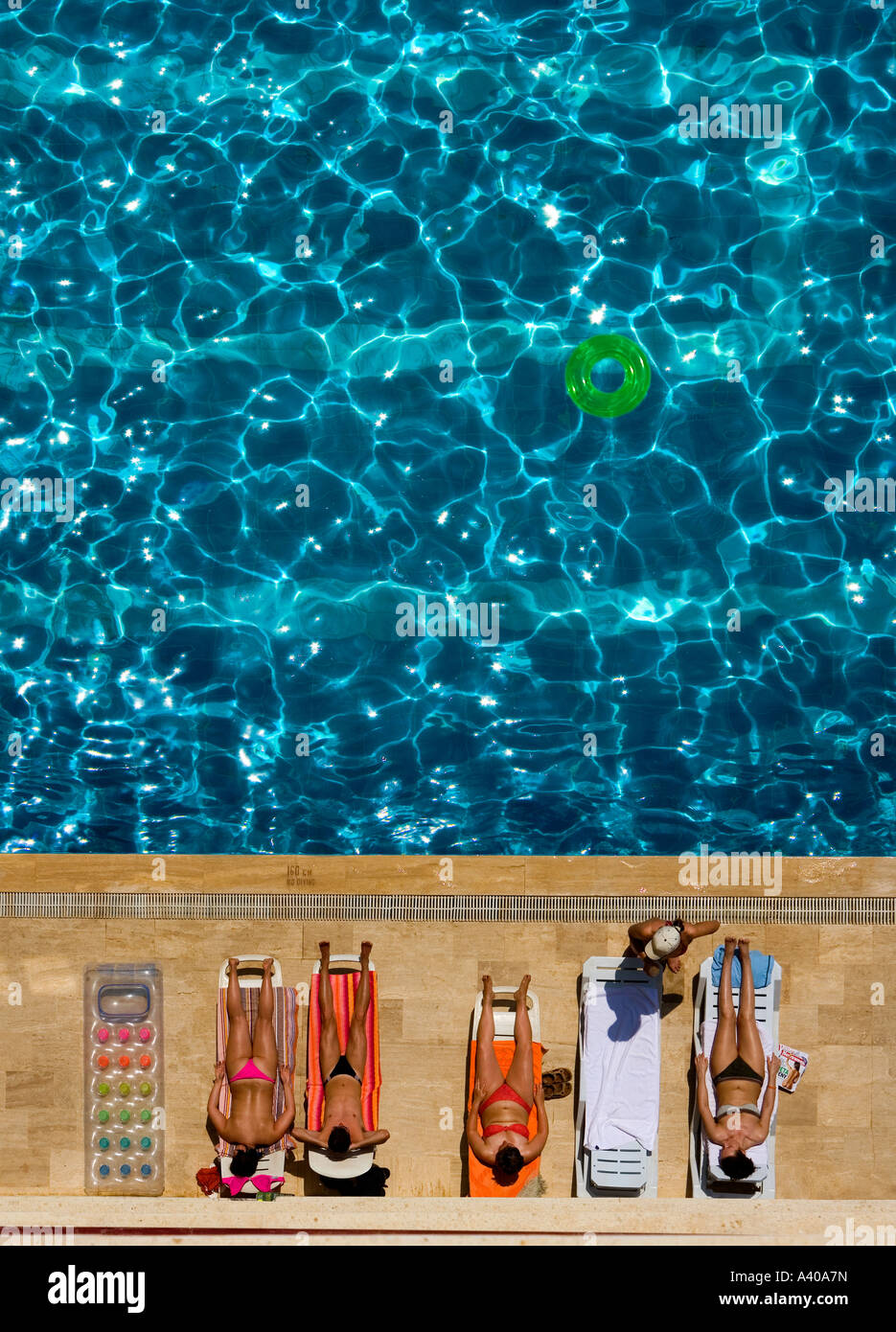 Tourists sunbathing by a pool Turkey Stock Photo - Alamy