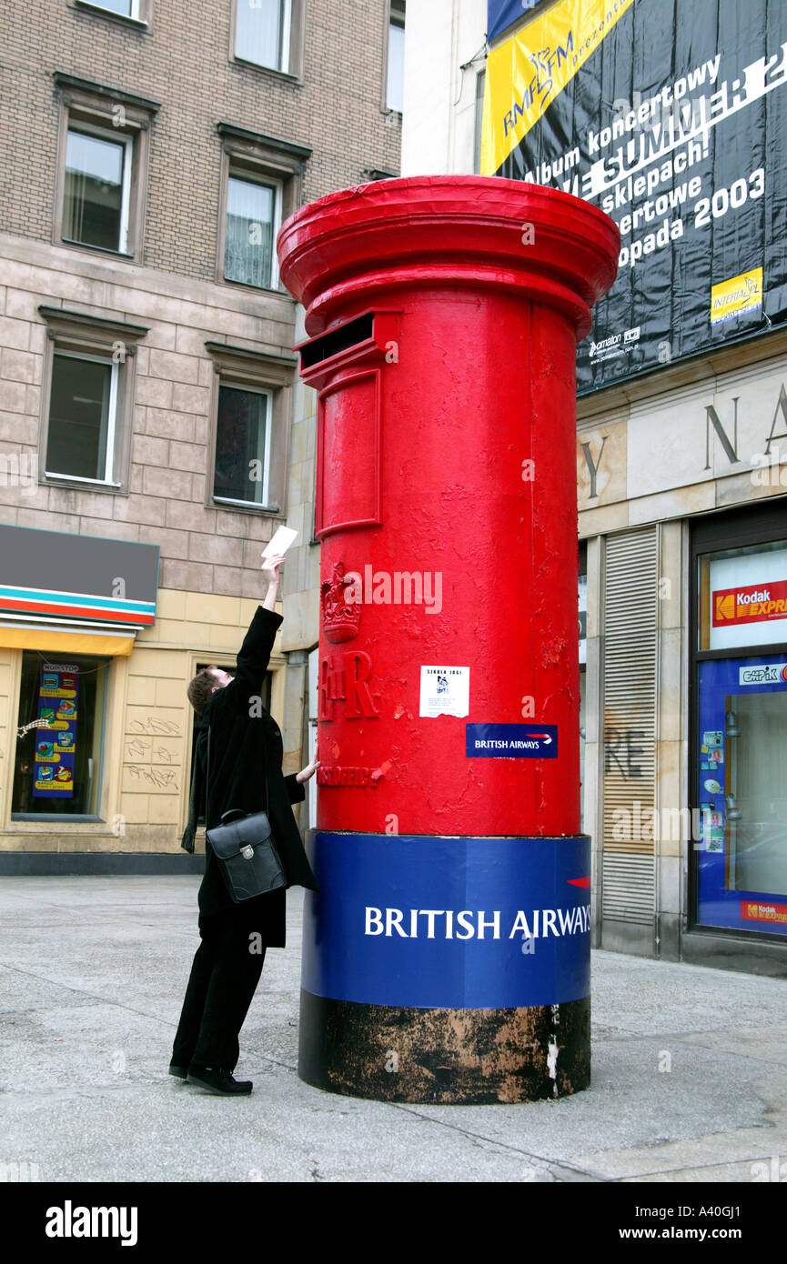 Man trying to post a letter in a big post box Stock Photo - Alamy