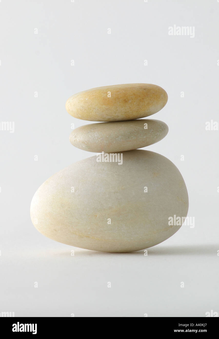 Three pebbles balanced with a white background Stock Photo - Alamy