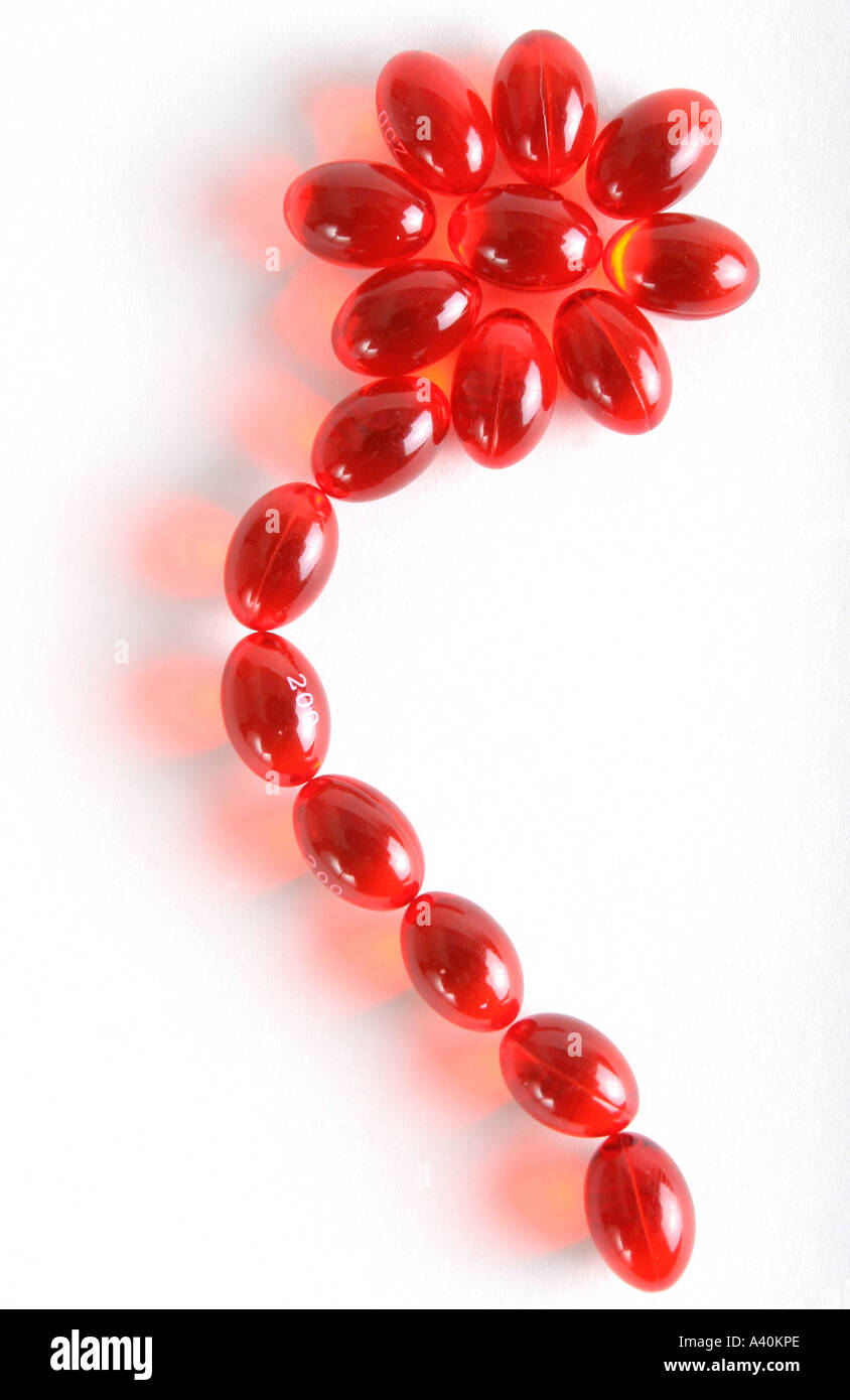 Red capsules of ibrupofen arranged as a flower on a white background ...