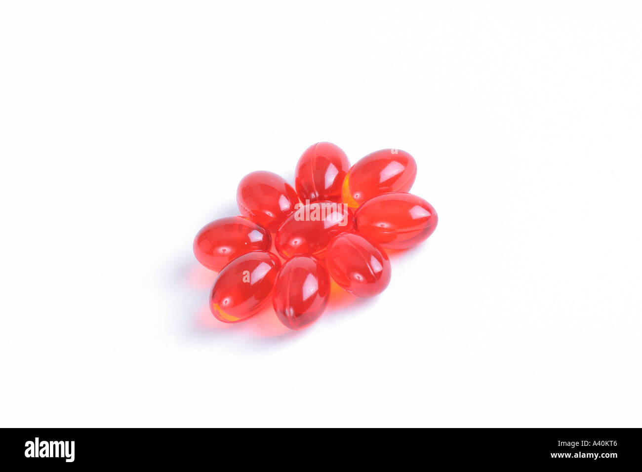 Red capsules of ibrupofen arranged as a flower on a white background ...