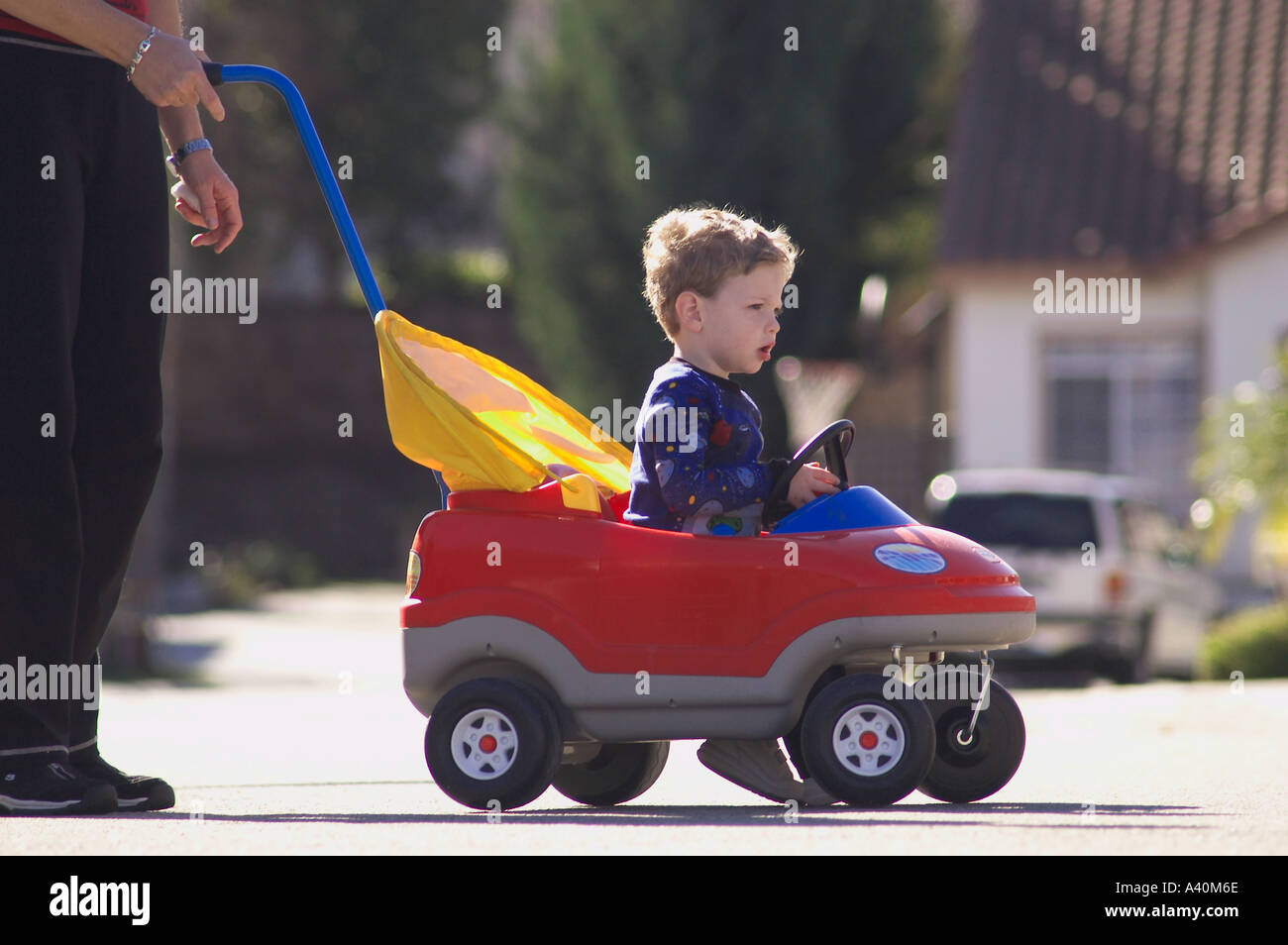 mother pushing baby in toy car Stock Photo - Alamy
