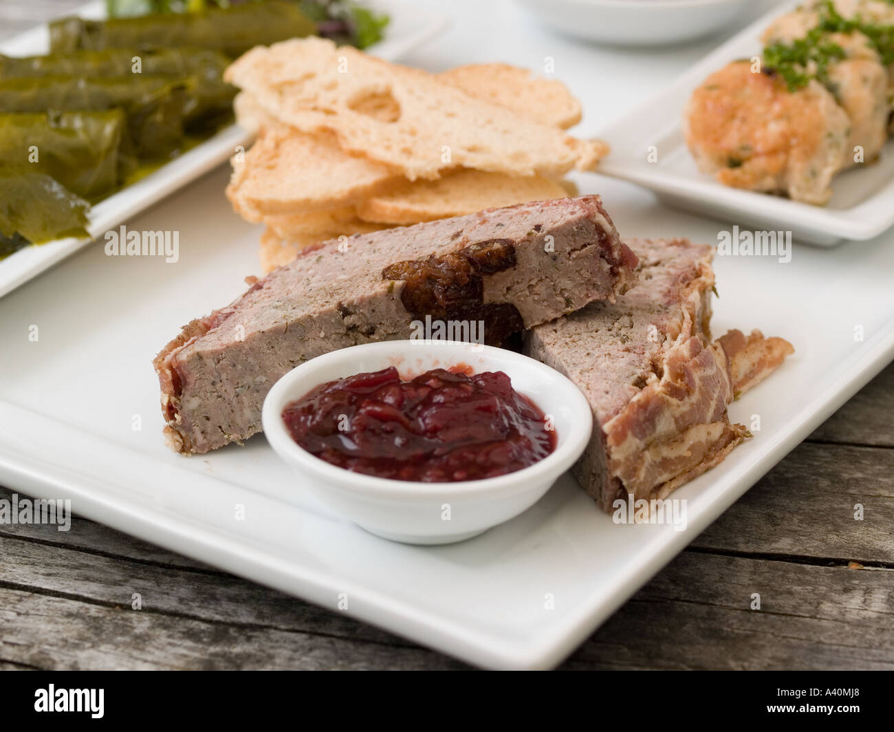 Platter of bacon wrapped meat pate terrine served with melba toast and ...