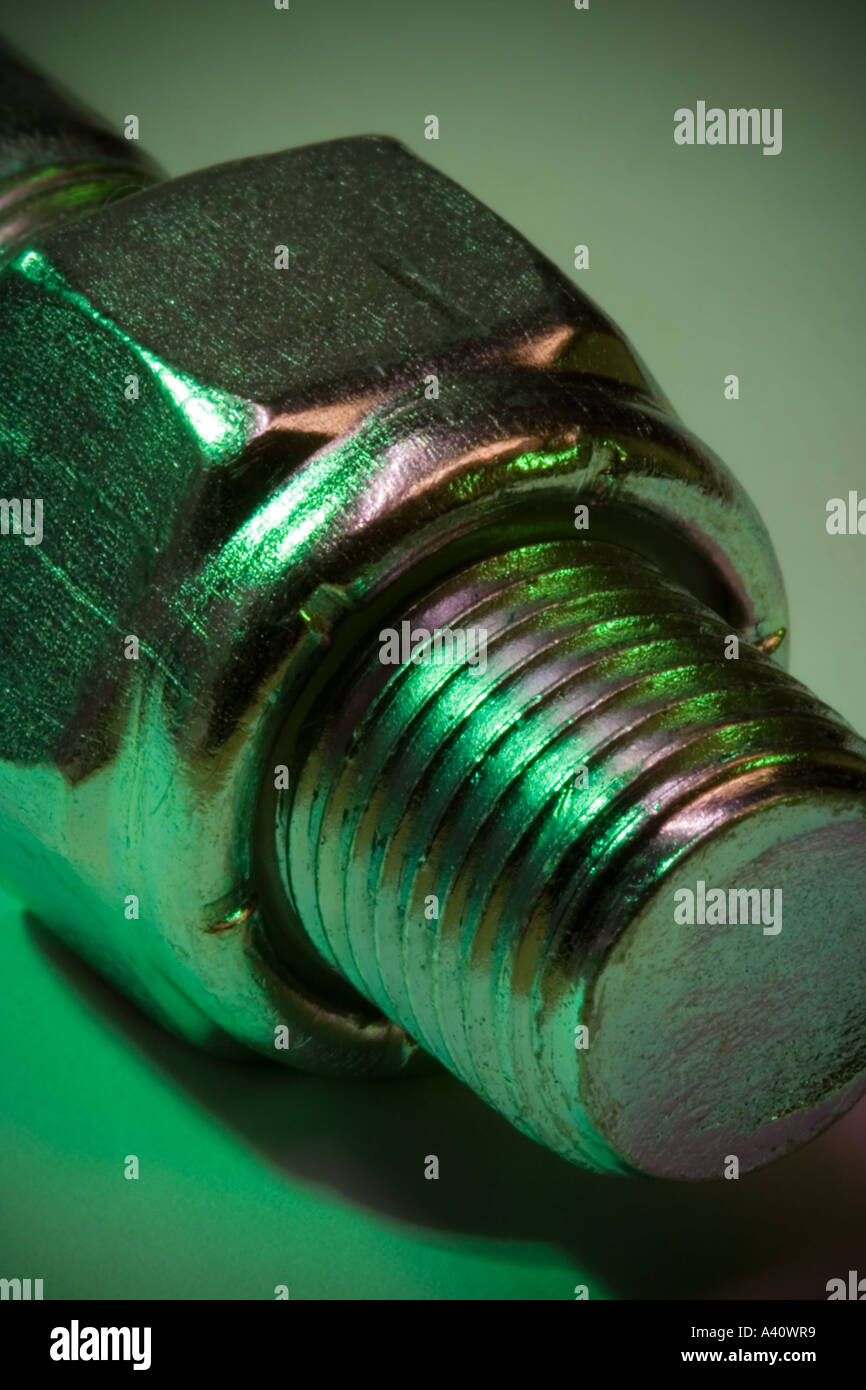 Threads of bolt protruding from nyloc locking nut, lit pale green Stock ...