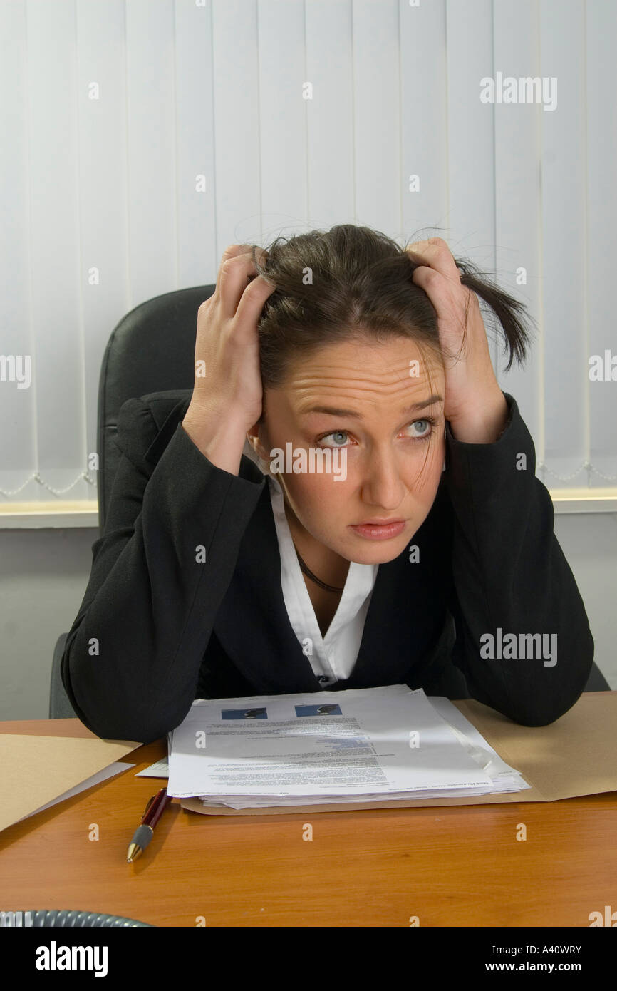 Bored or stressed Young female manager at office desk Stock Photo - Alamy