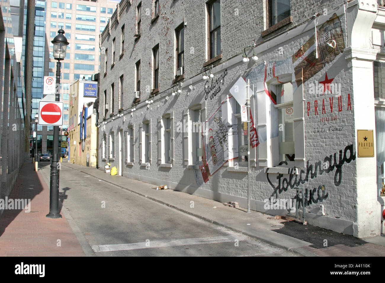 small street by white brick windowed building Stock Photo - Alamy