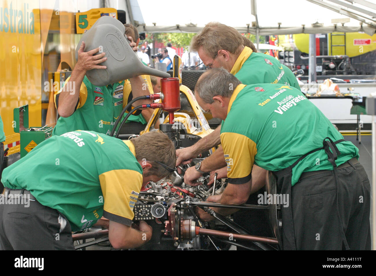 mechanics working on racing car in garage area Stock Photo - Alamy