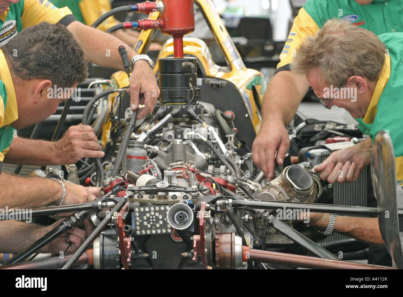 team of mechanics working on racing car engine Stock Photo - Alamy