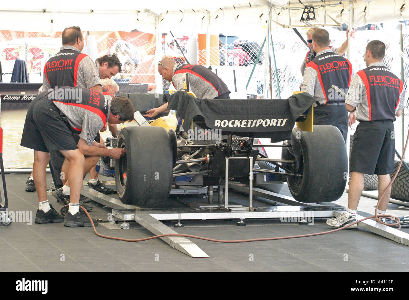 team of mechanics working on racing car Stock Photo - Alamy