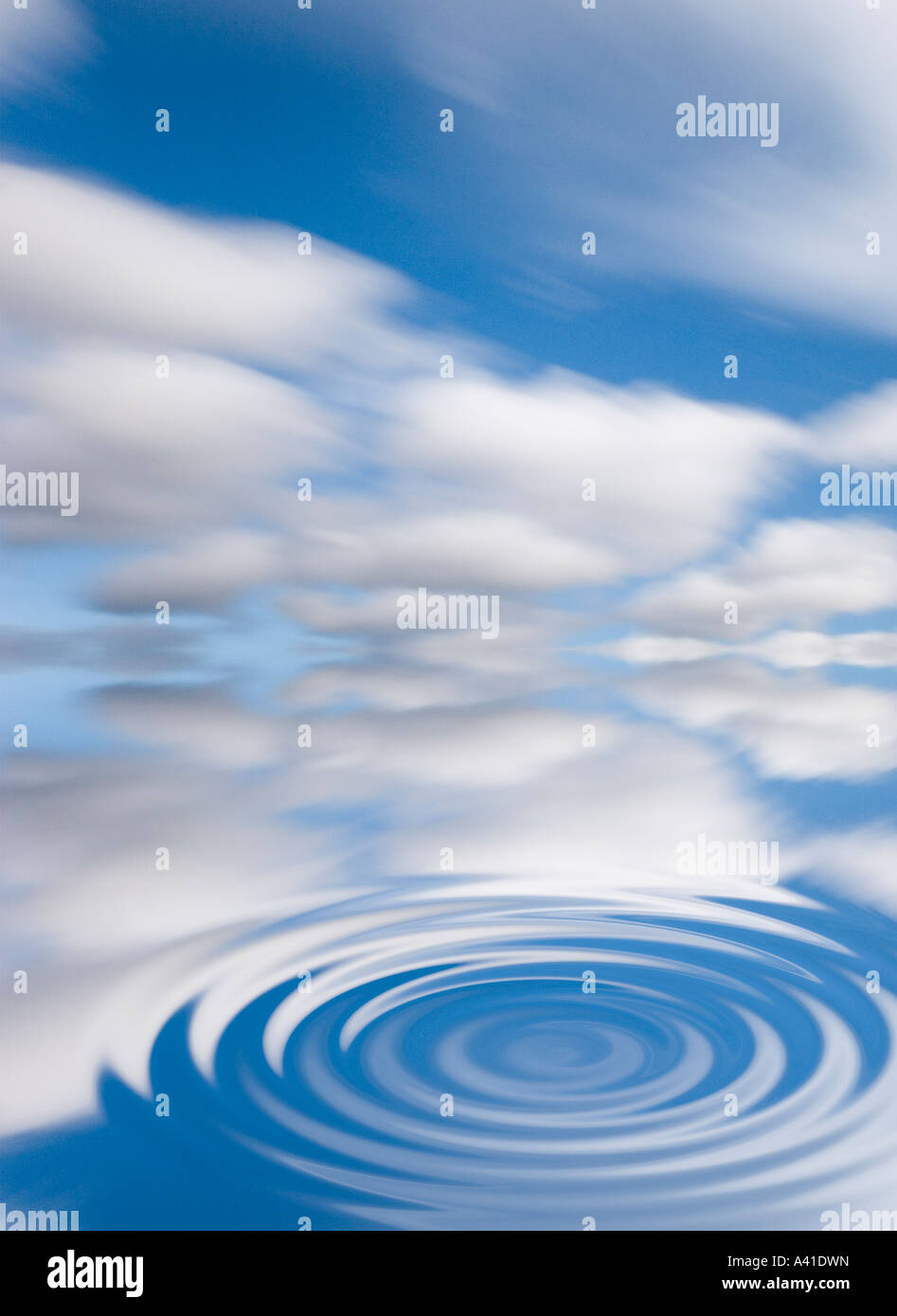 drifting clouds and blue water surface with concentric ripples ...