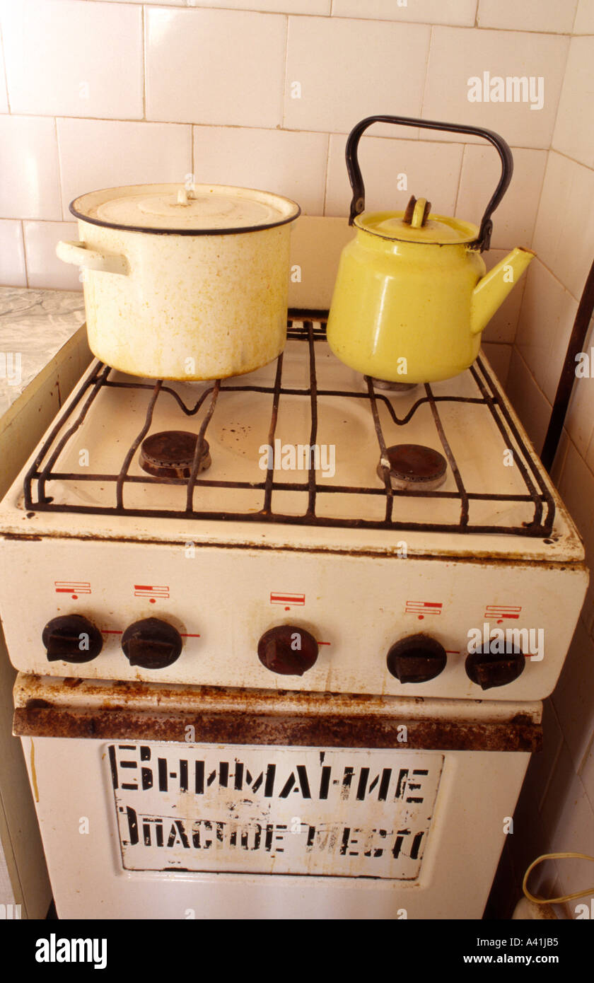 Kettle and tin pot on a gas stove with warning danger sign in Russian ...