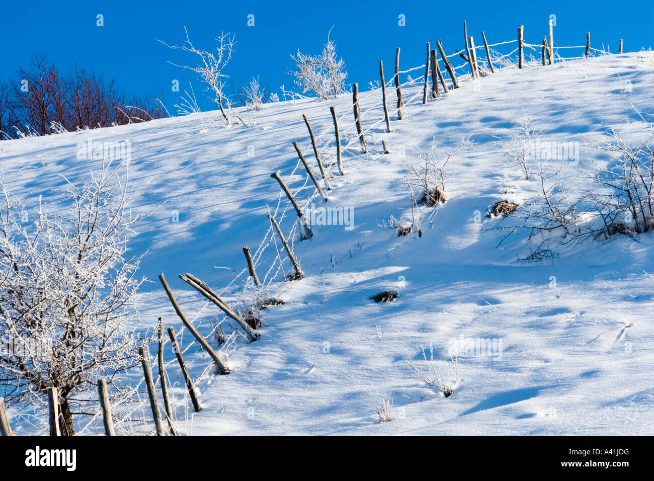 Snow and countryside village fence Stock Photo - Alamy