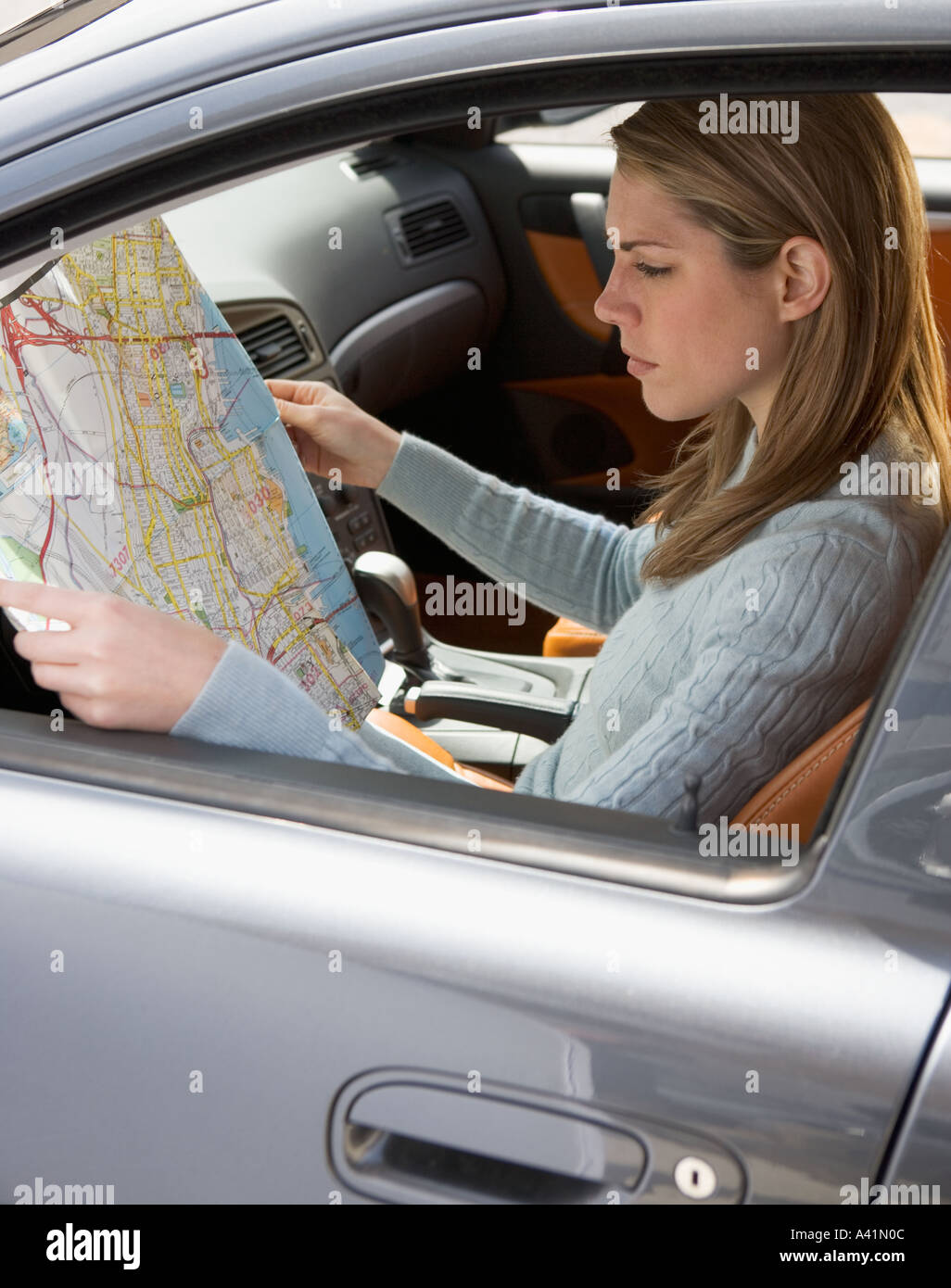 Woman in car looking at a map Stock Photo - Alamy