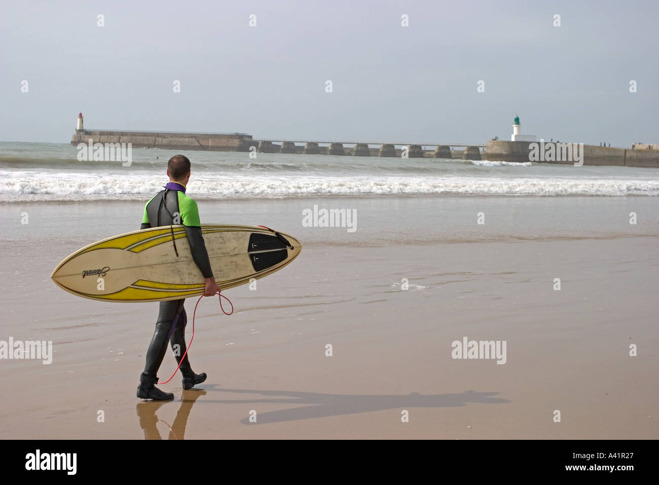 Surfer carrying surfboard Stock Photo - Alamy