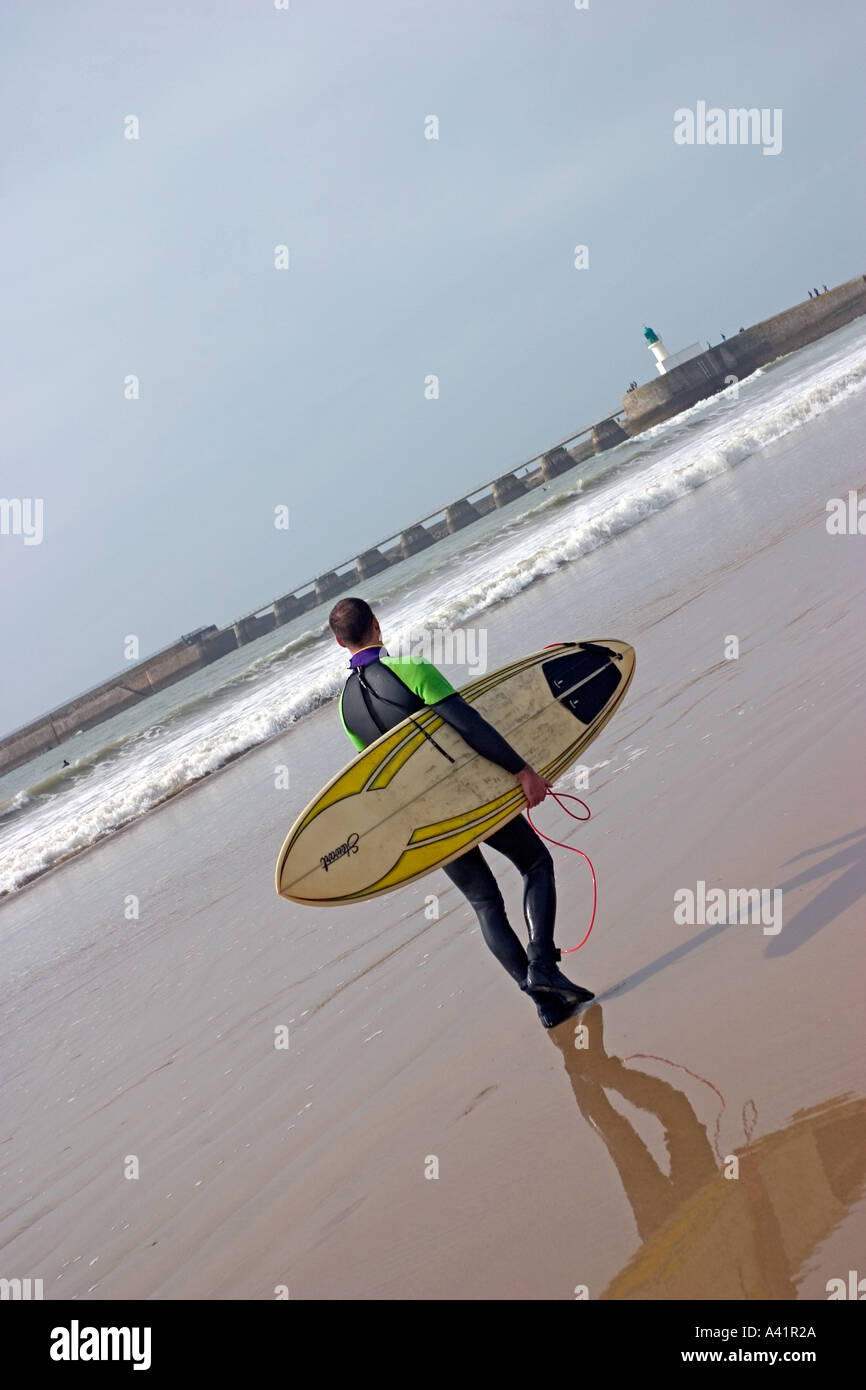 Surfer carrying surfboard Stock Photo - Alamy
