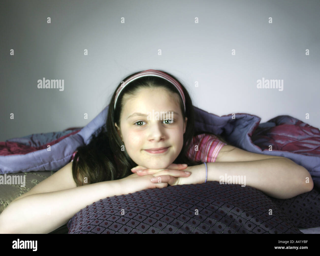 Young girl lay on her front facing the camera smiling Stock Photo - Alamy