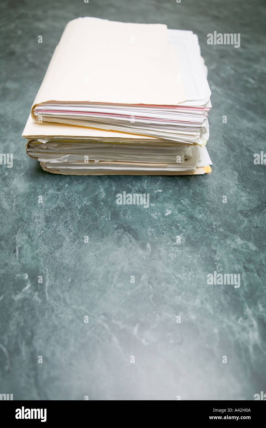 Files stacked on conference table Stock Photo - Alamy