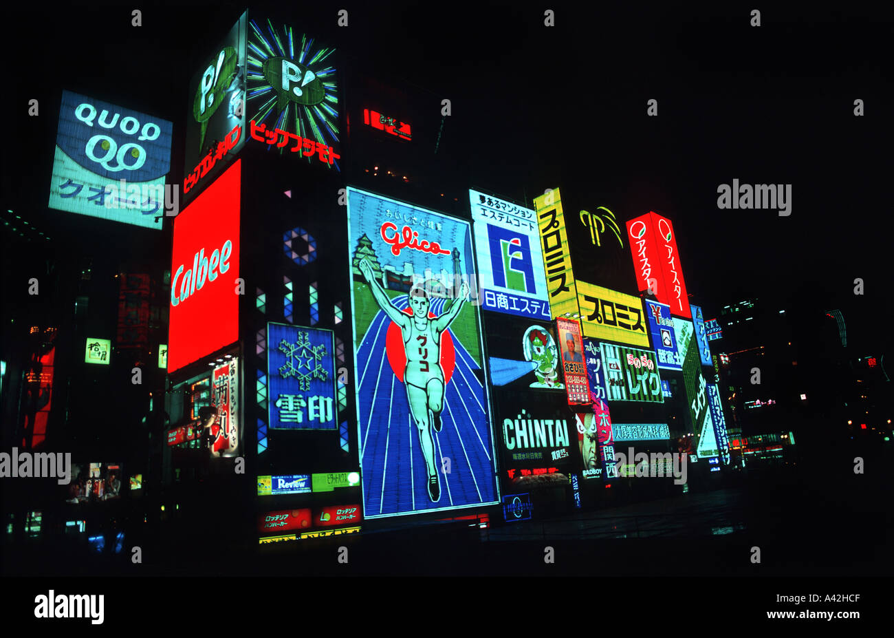 Neon signs illuminate the buildings beside the canal in Osaka s famous ...