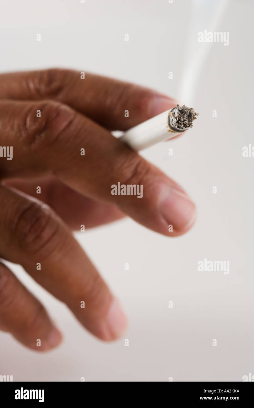 Close up of hand holding cigarette Stock Photo - Alamy