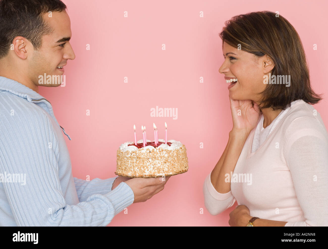 Profile of man holding cake and looking at woman Stock Photo - Alamy
