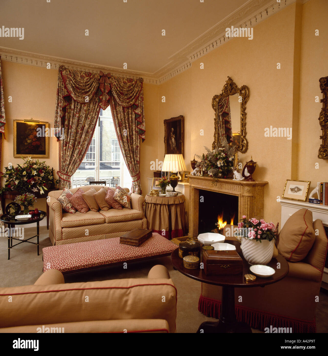 Eighties sittingroom with sofa beside fireplace and patterned drapes at ...