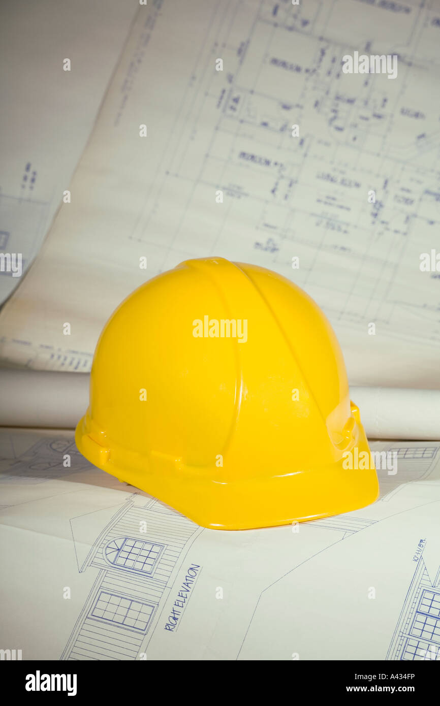 Yellow hard hat on blueprints for home Stock Photo - Alamy
