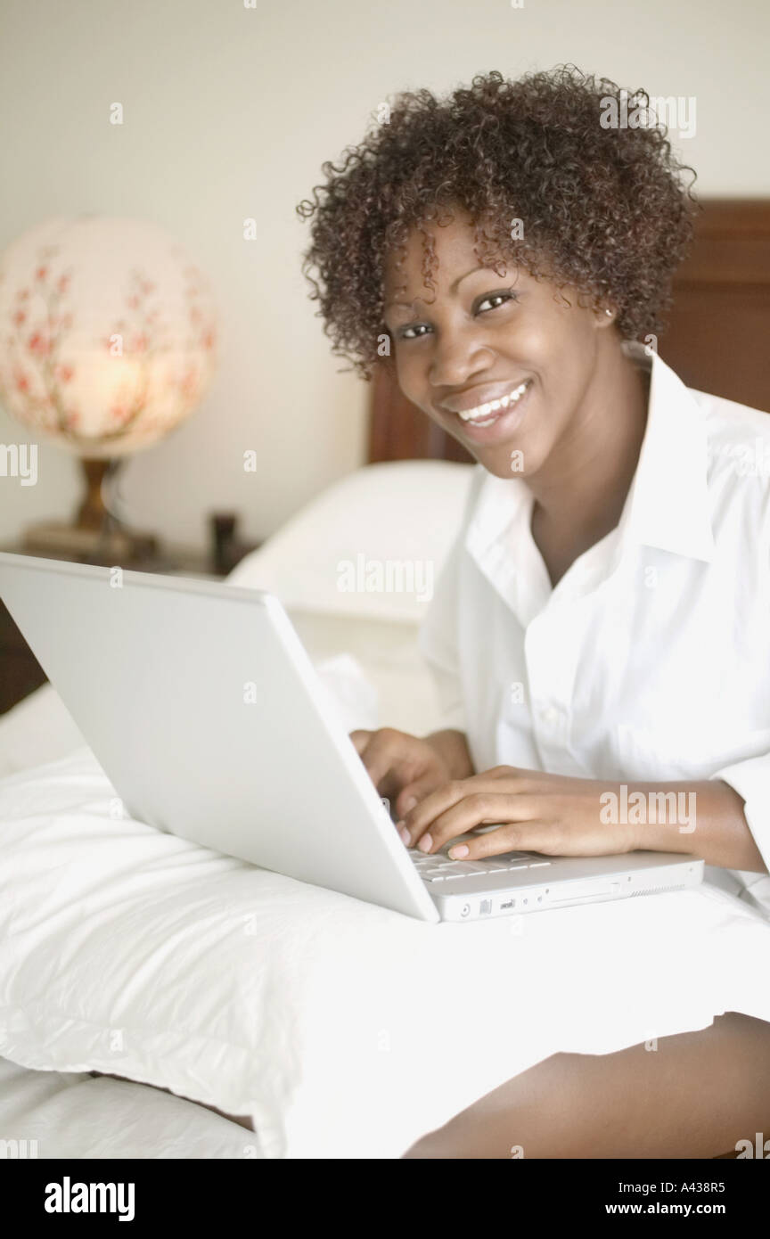 Portrait of woman in bed with laptop Stock Photo - Alamy
