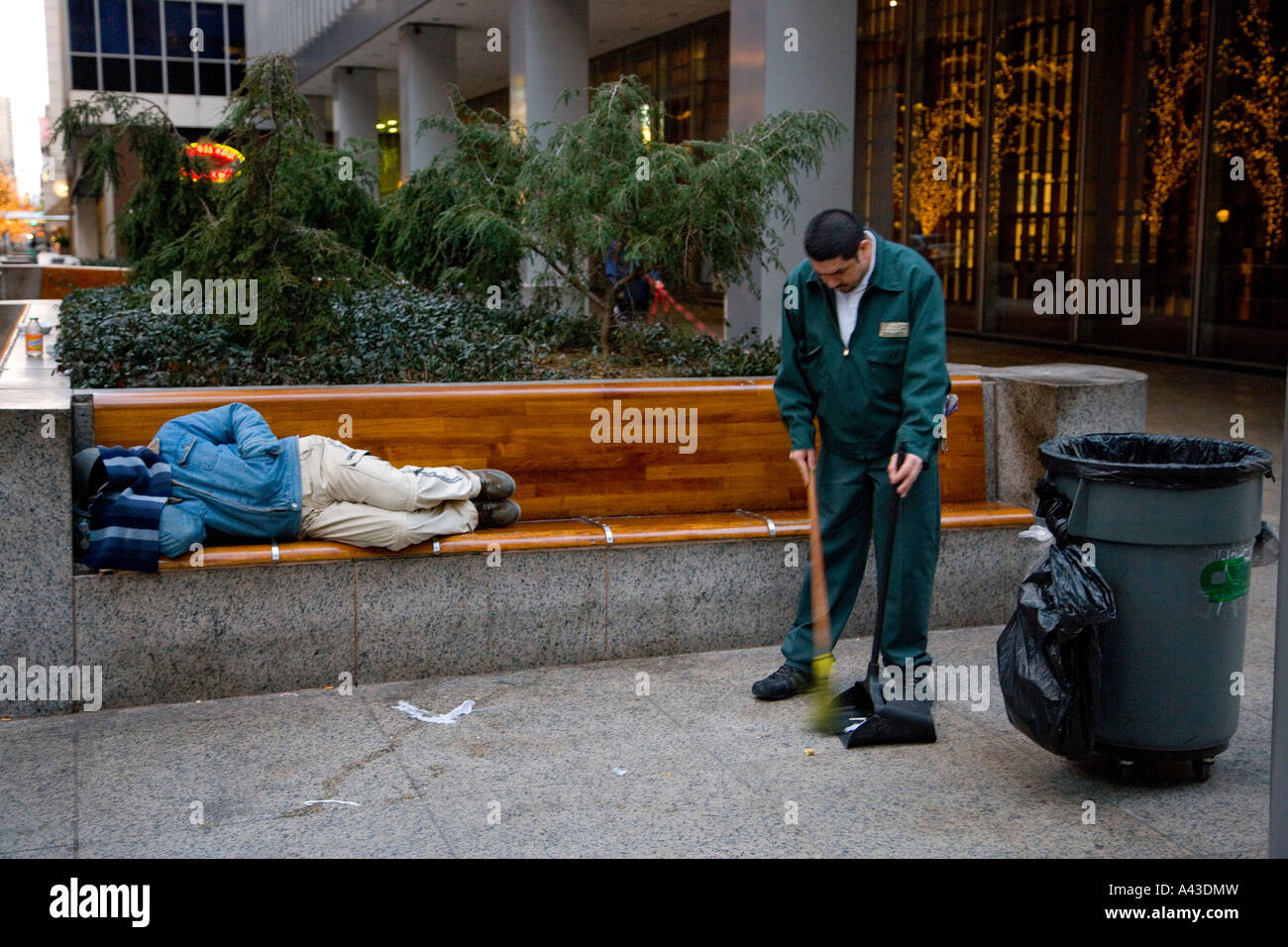 streetcleaner working around homeless man sleeping on bench Stock Photo ...