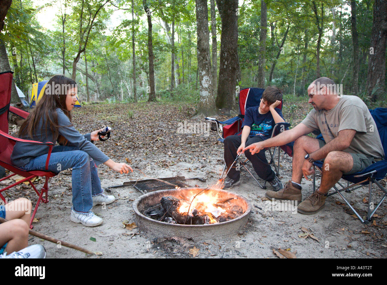 Family sitting around campfire making smores at Manatee Springs State ...