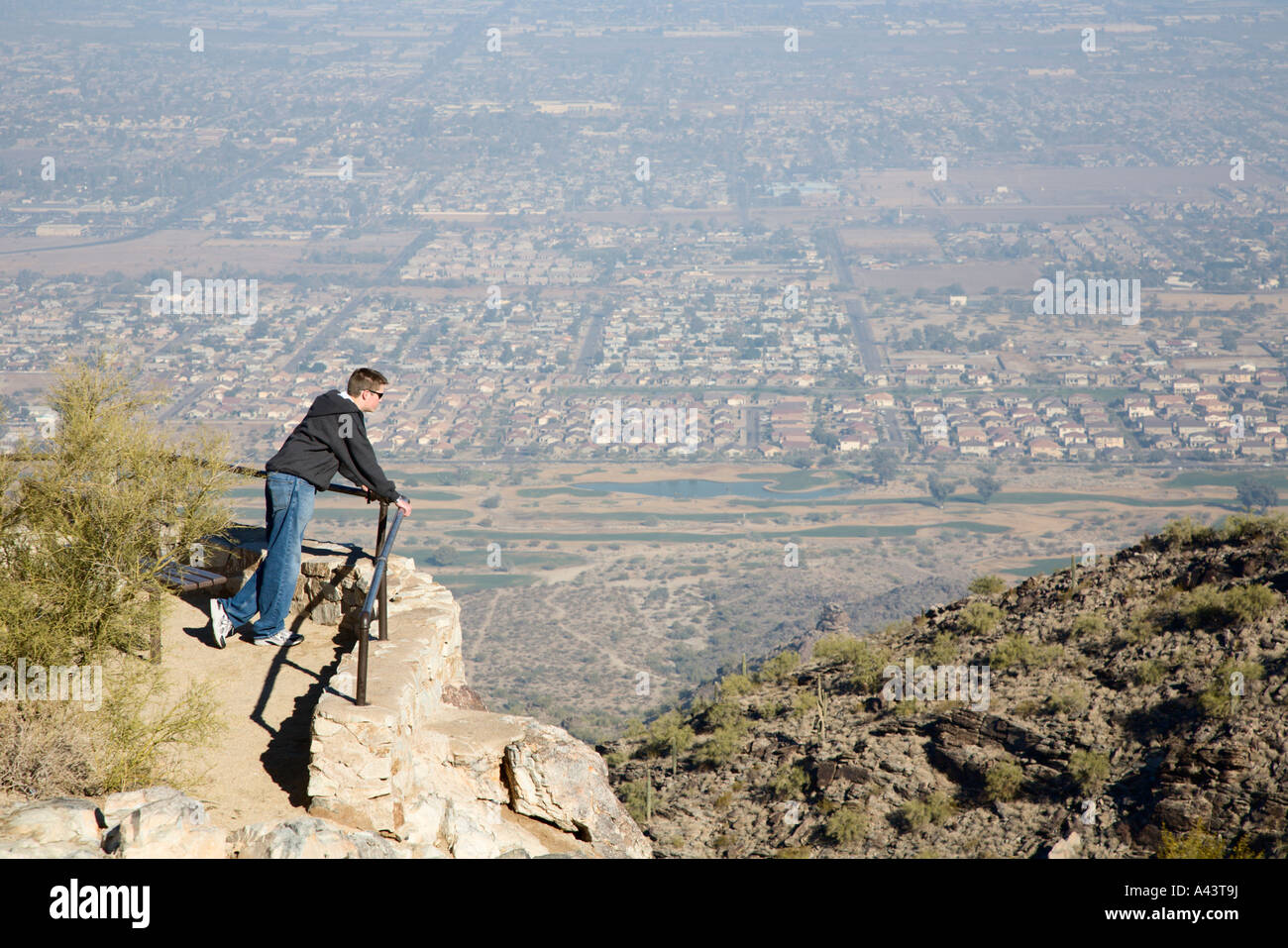 Teenage boy looking down at city of Phoenix, Arizona from scenic ...