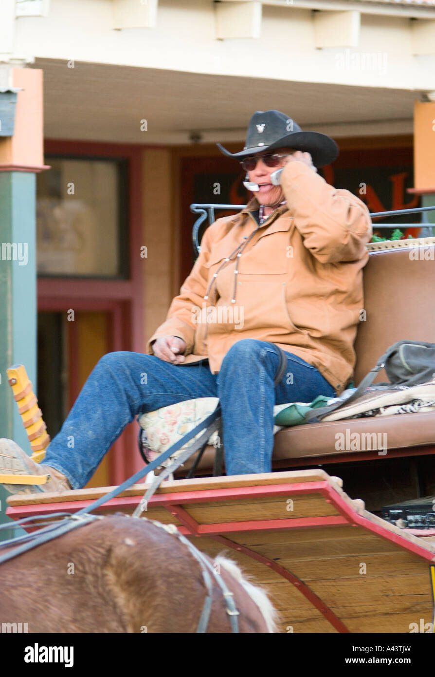 Stagecoach driver character talks on cell phone Stock Photo - Alamy