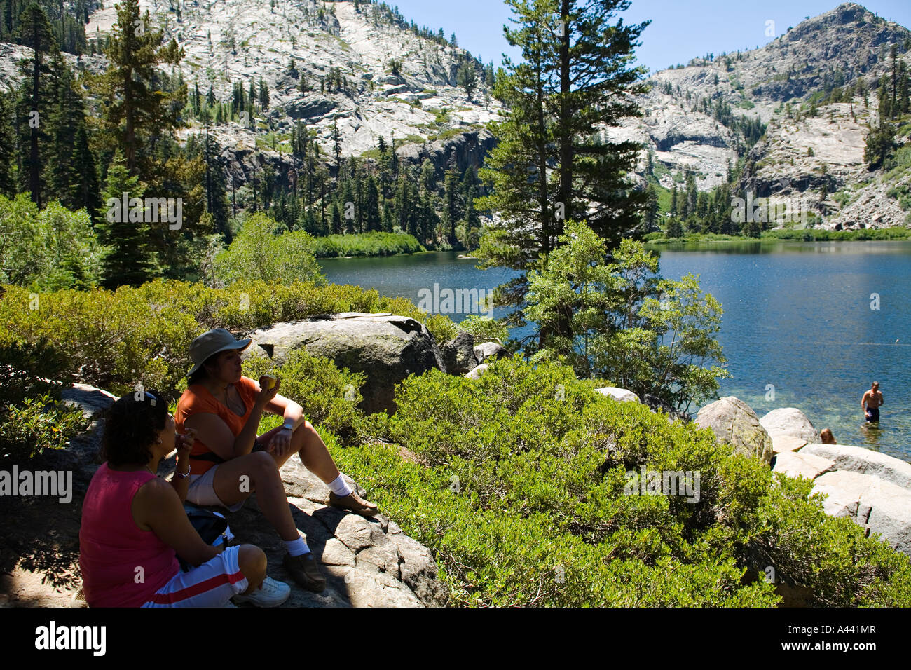 CALIFORNIA Two women sit and eat lunch in shade near Eagle Lake people ...