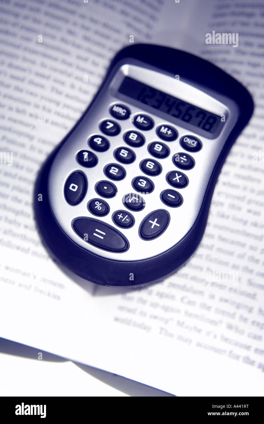 Calculator on book Stock Photo - Alamy
