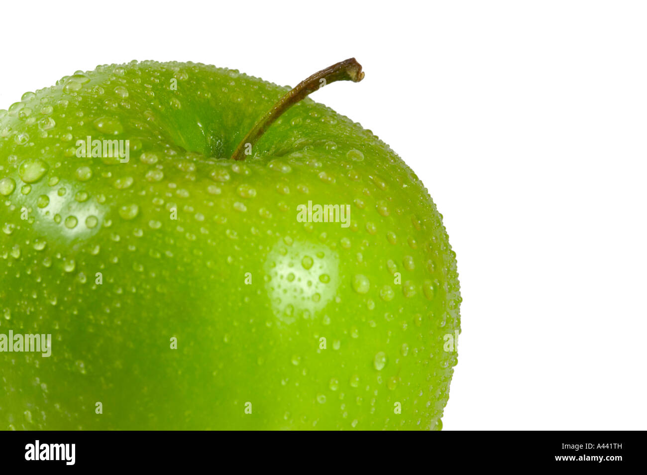 Wet green apple isolated on white framed in the bottom left corner ...