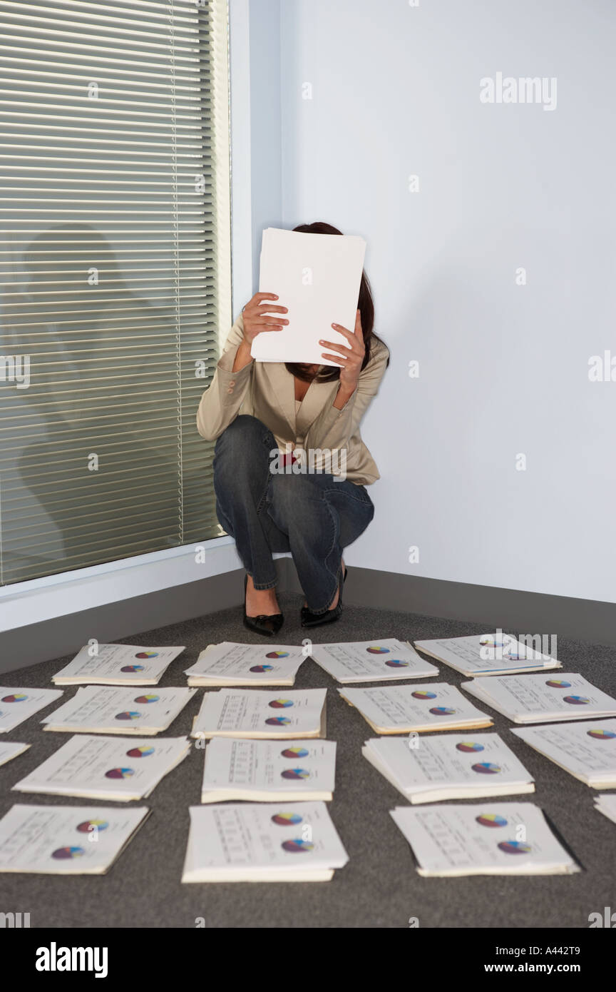 Businesswoman hiding face with papers Stock Photo - Alamy