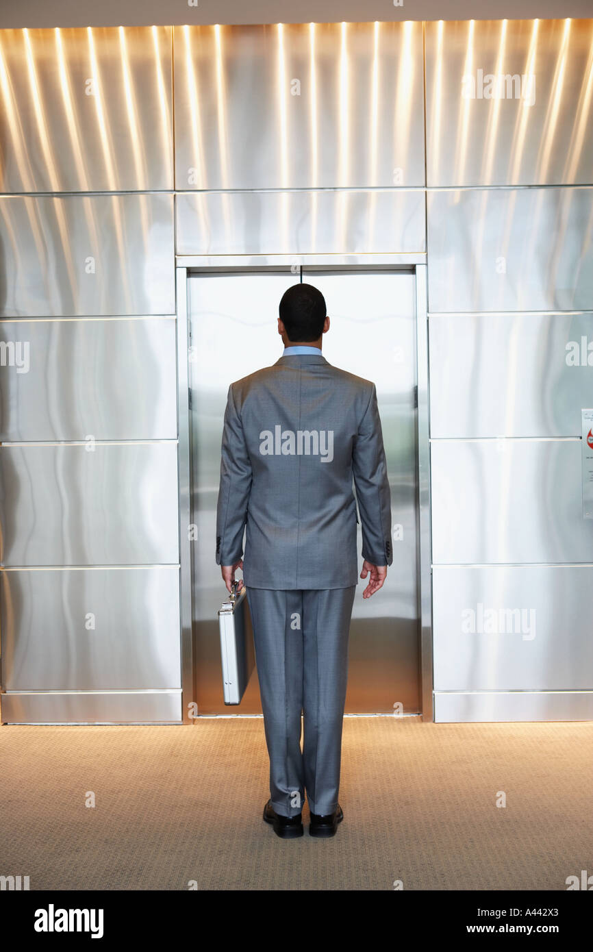 Businessman waiting for elevator Stock Photo - Alamy