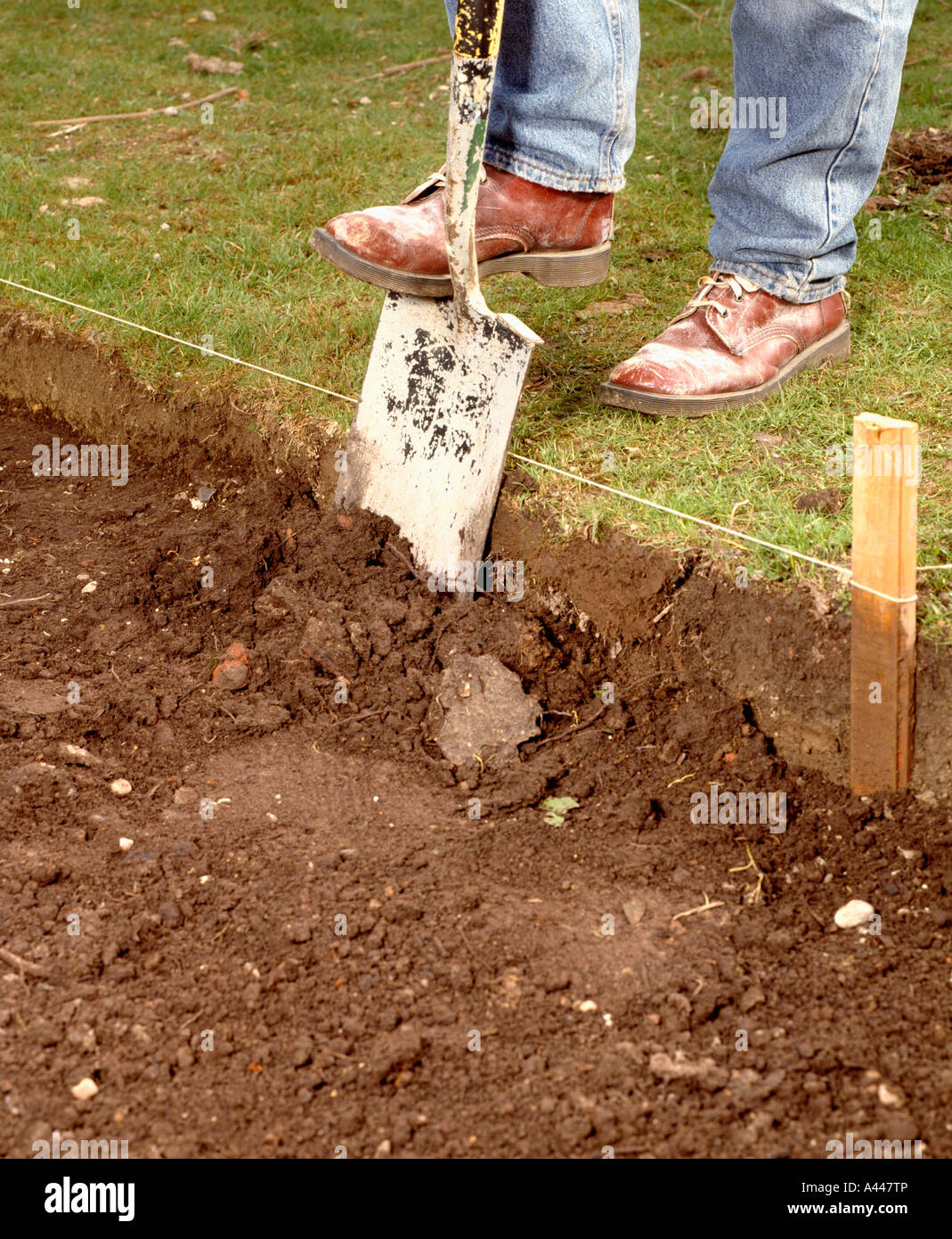 Close-up of man digging ground to make new path Stock Photo - Alamy