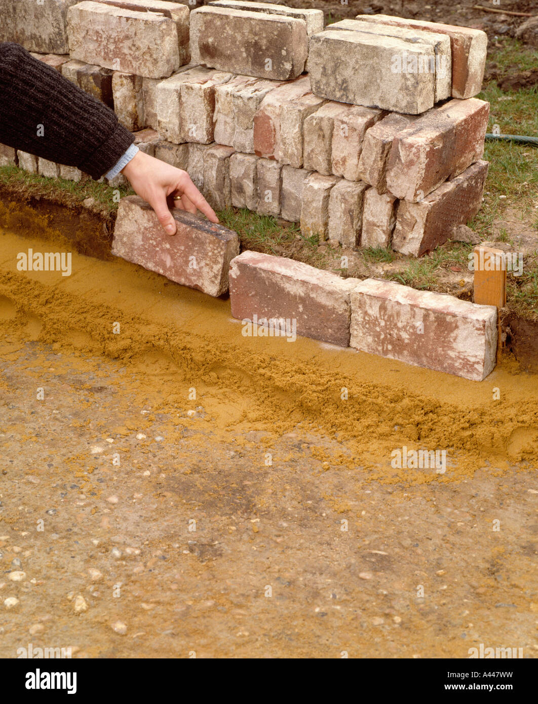 Close-up of man laying path with old bricks Stock Photo - Alamy