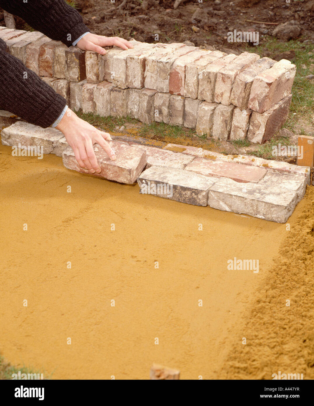 Close-up of man laying path with old bricks Stock Photo - Alamy