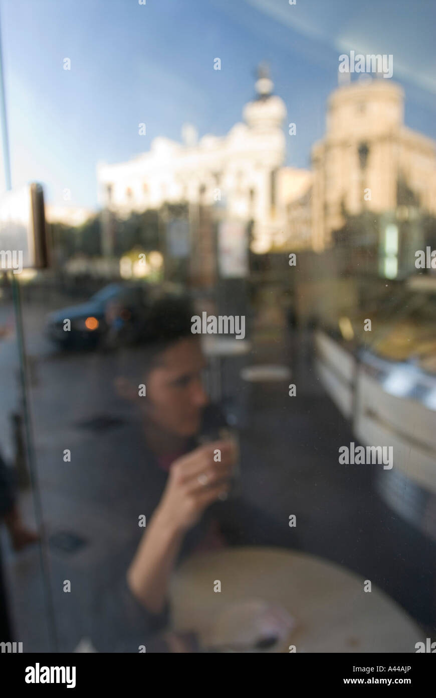 Woman drinking coffee at a cafe, looking in through a window Stock ...