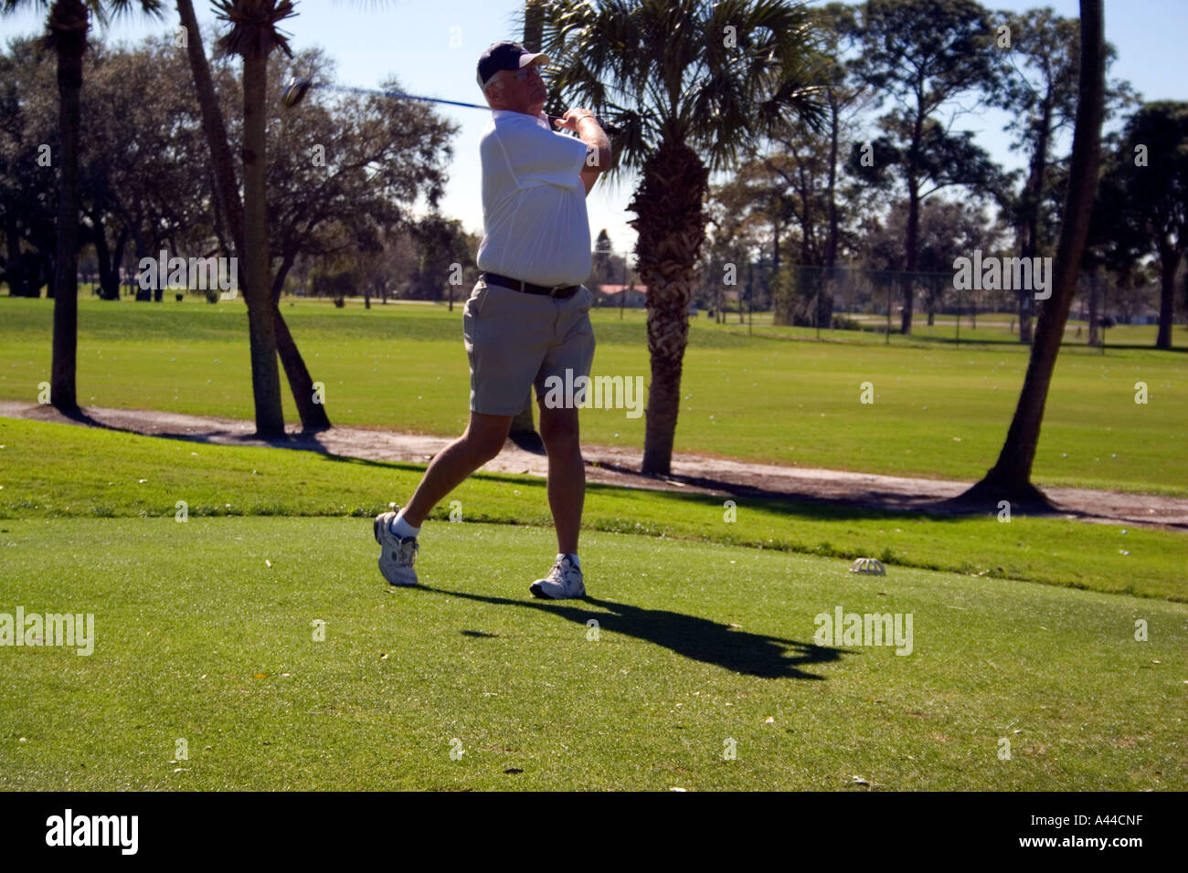 Male golfer following through after hitting a golf ball in Florida ...