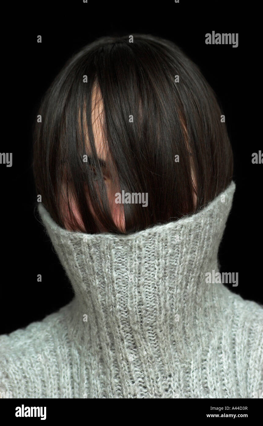 Young woman with jumper over head hair stretching across face close up ...