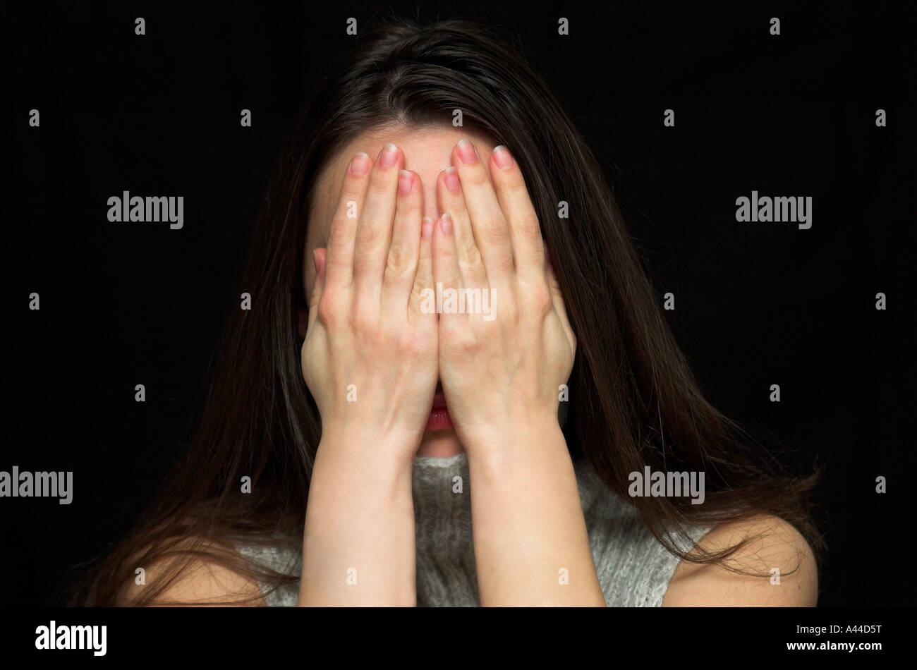 Young woman covering face with hands Stock Photo - Alamy