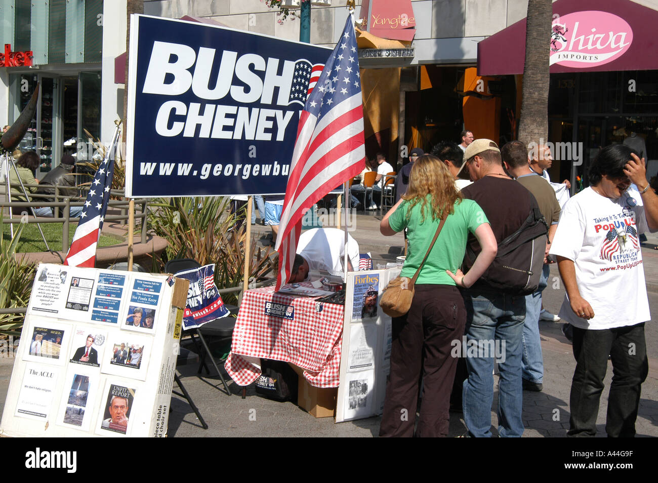 Election campaign, people near table with Bush and Cheney advertisement ...