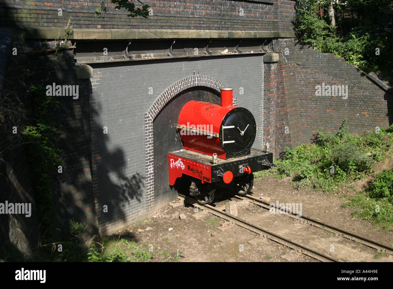 A train coming out of a tunnel The shell of an old steam train has been ...