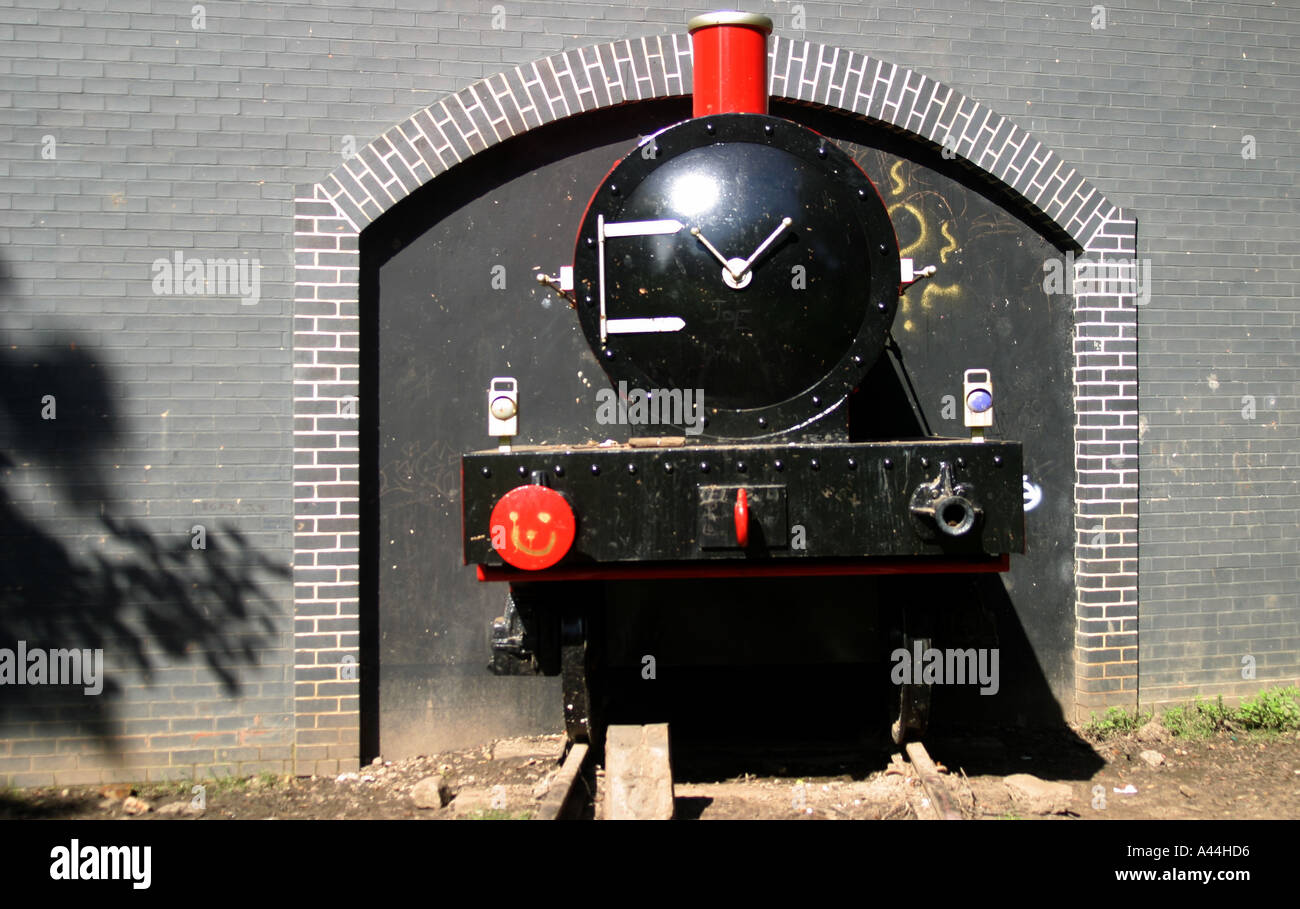 A train coming out of a tunnel The shell of an old steam train has been ...